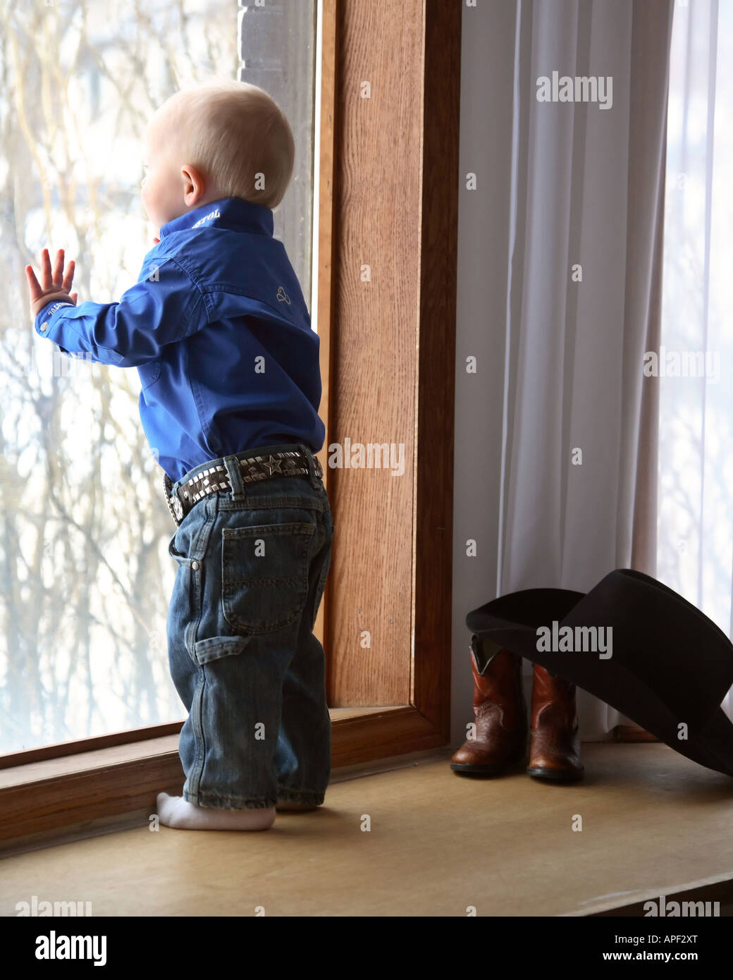 Young cowboy looking outside Stock Photo - Alamy