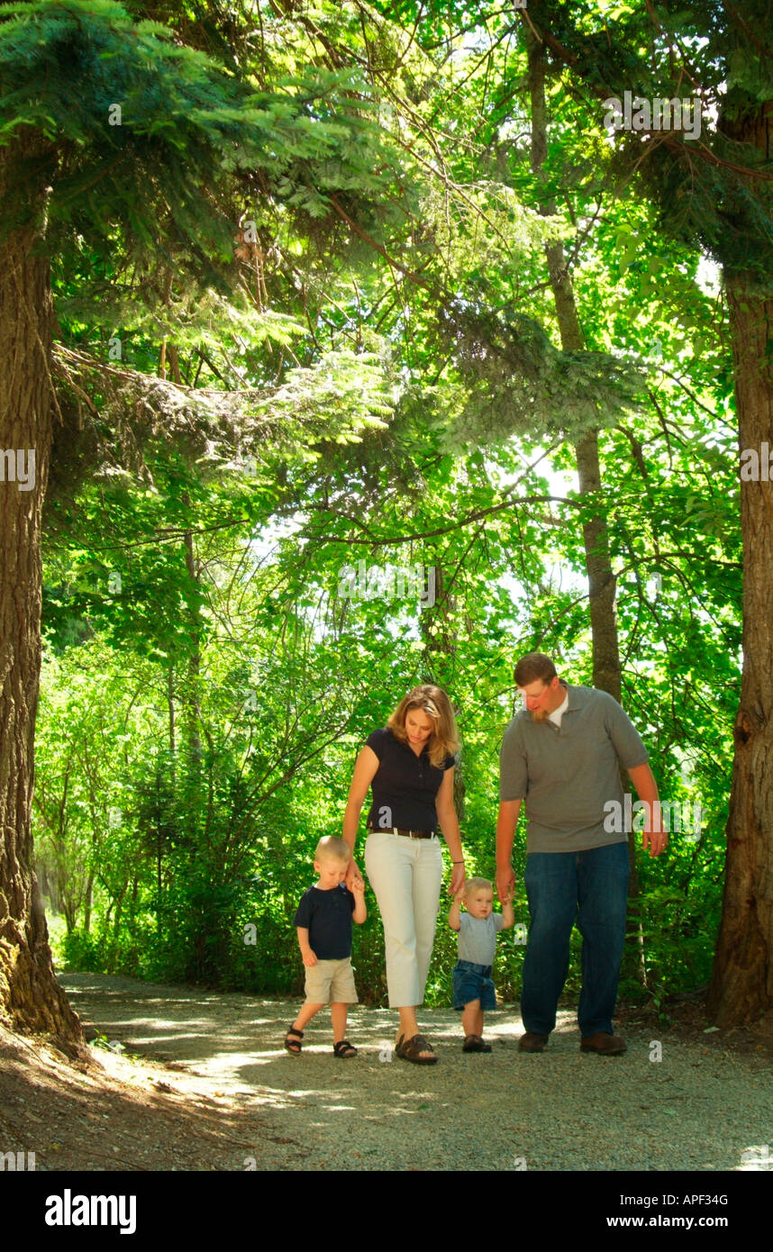 Family with two kids walking through woodland pathway Stock Photo - Alamy