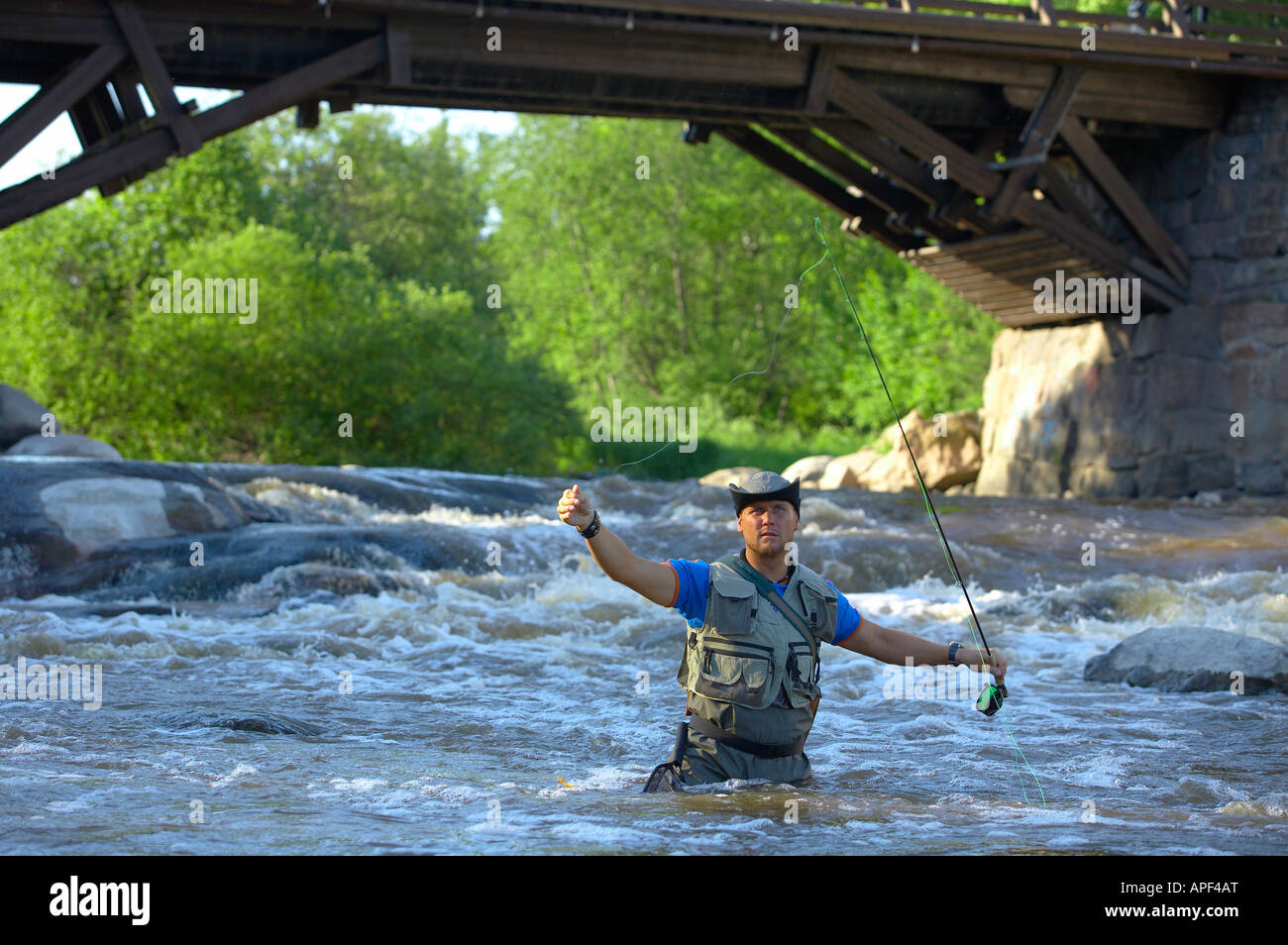 man wading in a river fly fishing Stock Photo - Alamy