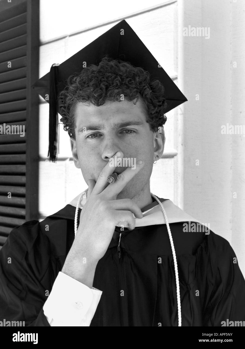 Young man smoking a cigar on the front porch after graduation. MR Stock ...