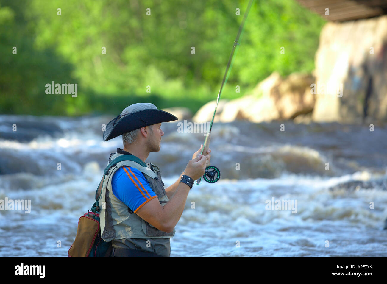 man wading in a river fly fishing Stock Photo - Alamy