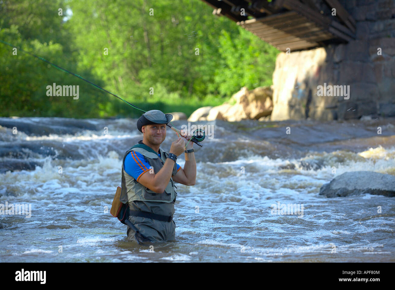 man wading in a river fly fishing Stock Photo - Alamy