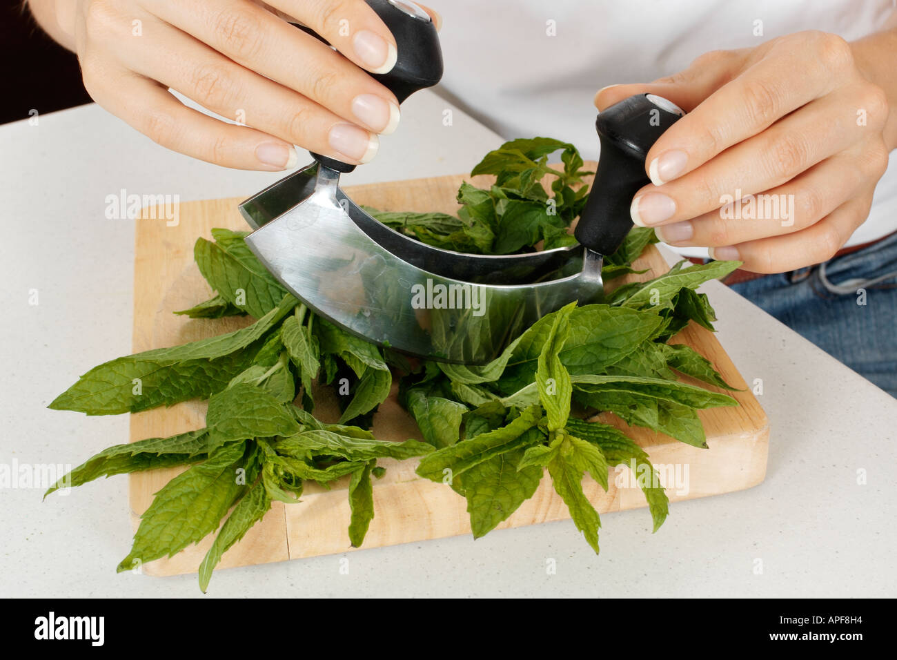 WOMAN IN KITCHEN CHOPPING MINT WITH HACHOIR / MEZZALUNA Stock Photo - Alamy