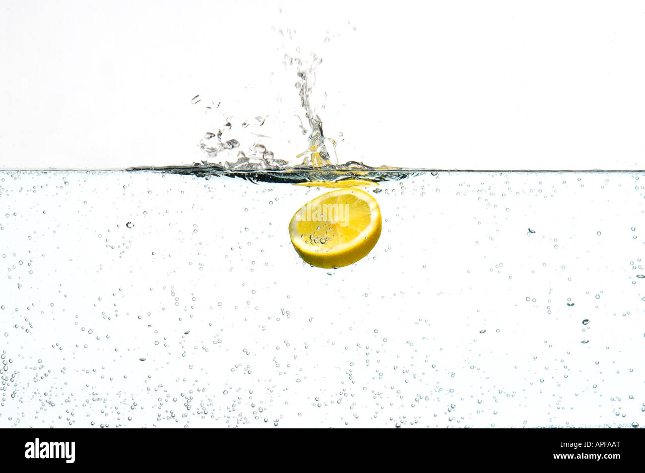 Slice of lemon splashing dropping into fizzy carbonated water Stock ...