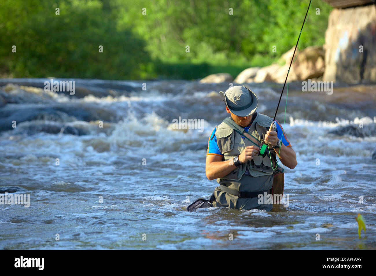 man wading in a river fly fishing Stock Photo - Alamy