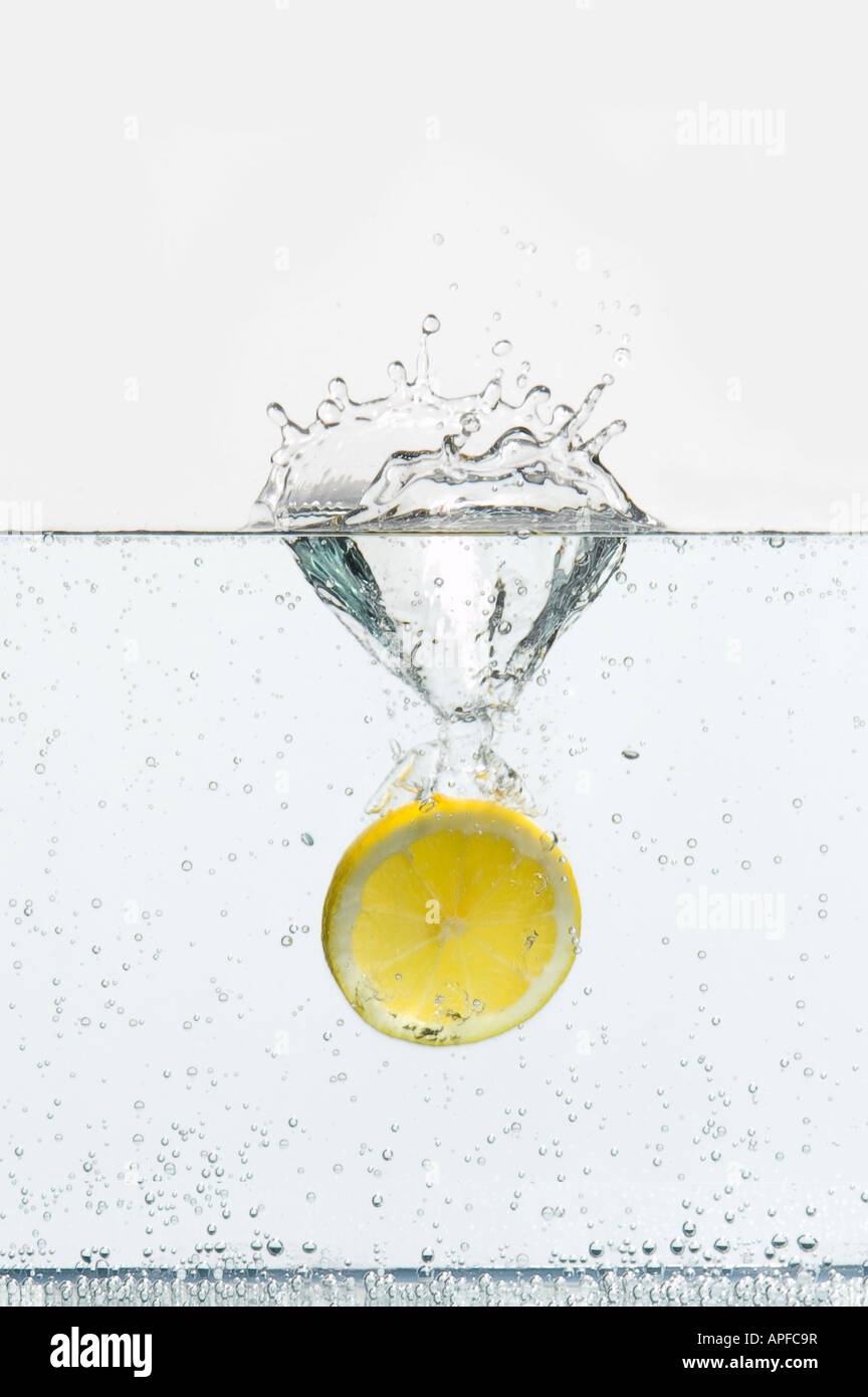 Slice of lemon splashing dropping into fizzy carbonated water Stock ...