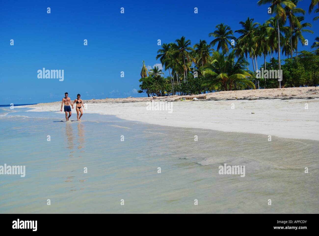 Couple walking hand in hand along Punta Popy beach, Dominican Republic ...