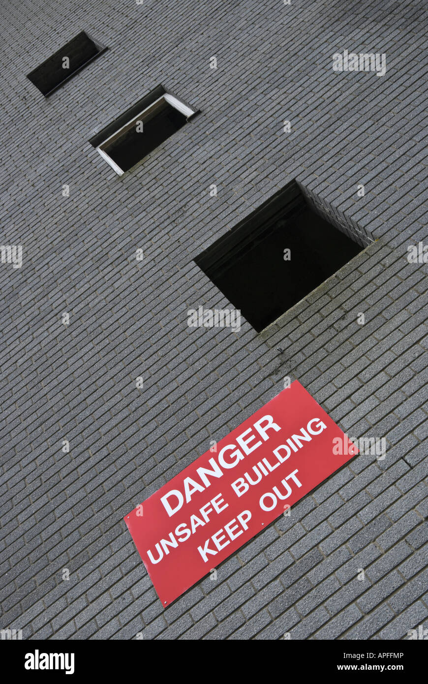 A derelict building with a warning sign "Danger unsafe building keep ...