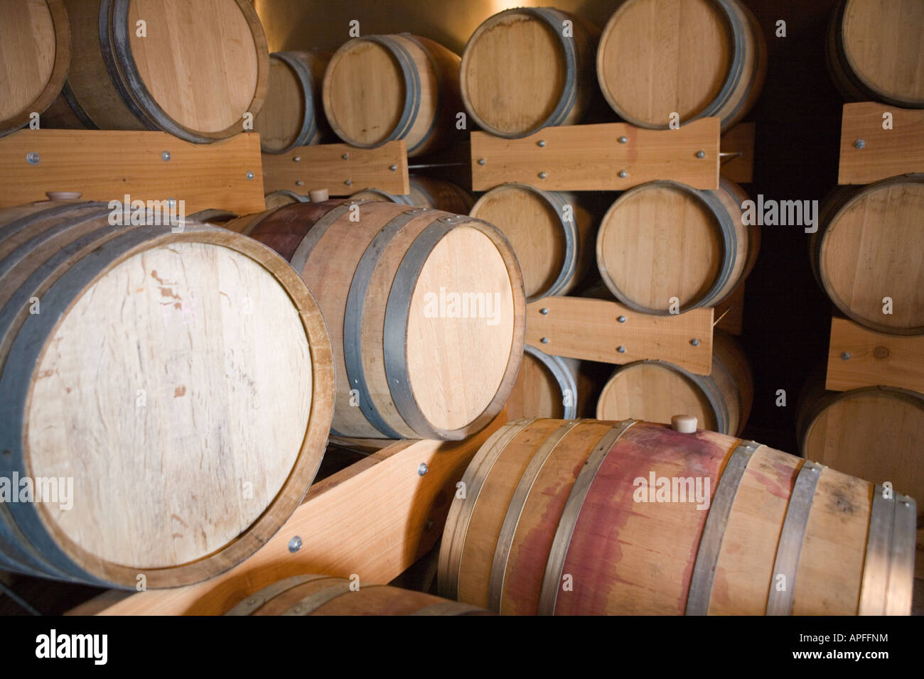 Wine barrels sit in a barn aging Stock Photo - Alamy