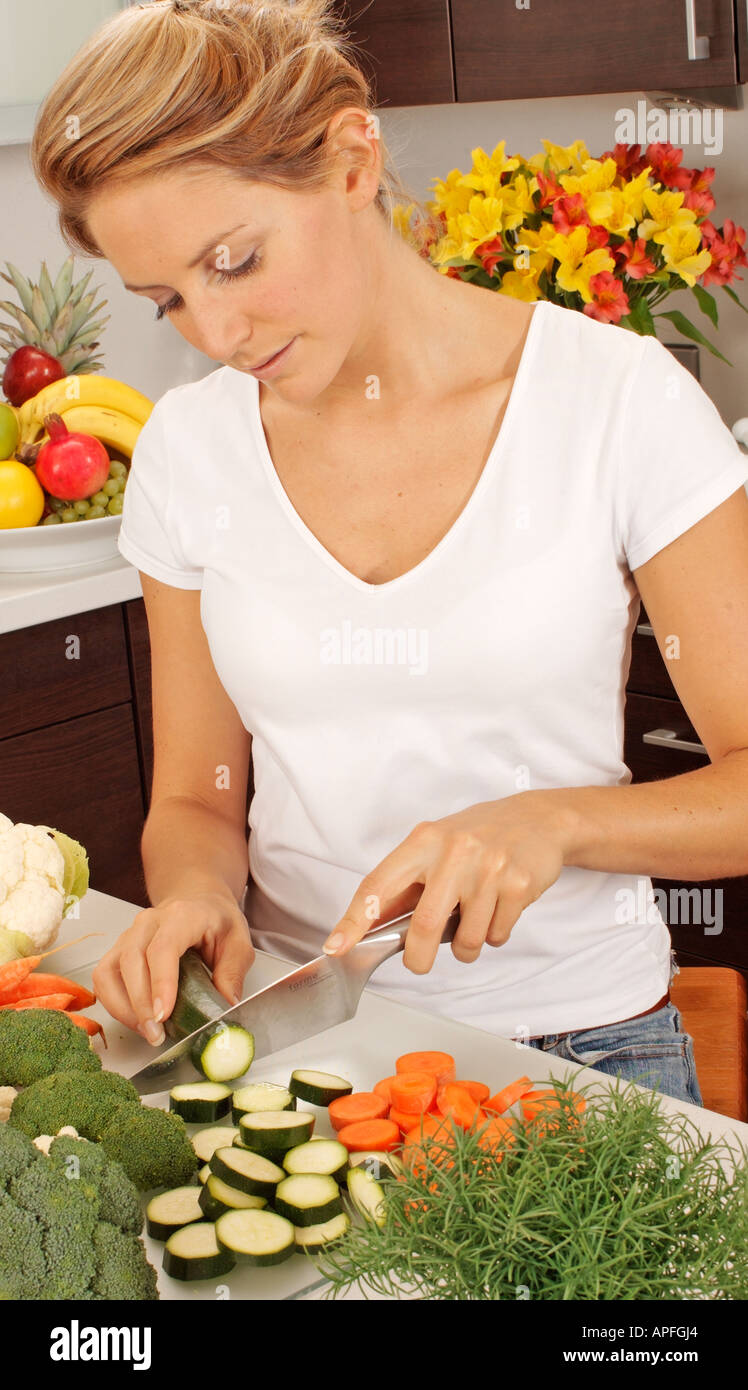 WOMAN IN KITCHEN CHOPPING COURGETTES / ZUCCHINI Stock Photo - Alamy