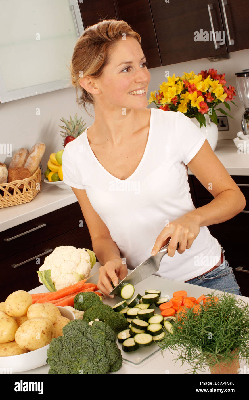 WOMAN IN KITCHEN CHOPPING COURGETTES / ZUCCHINI Stock Photo - Alamy