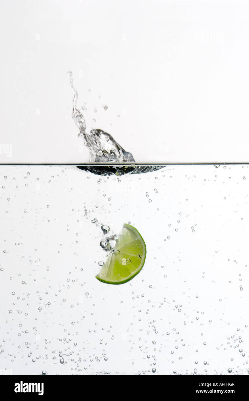 Slice of lime splashing dropping into fizzy carbonated water Stock Photo - Alamy