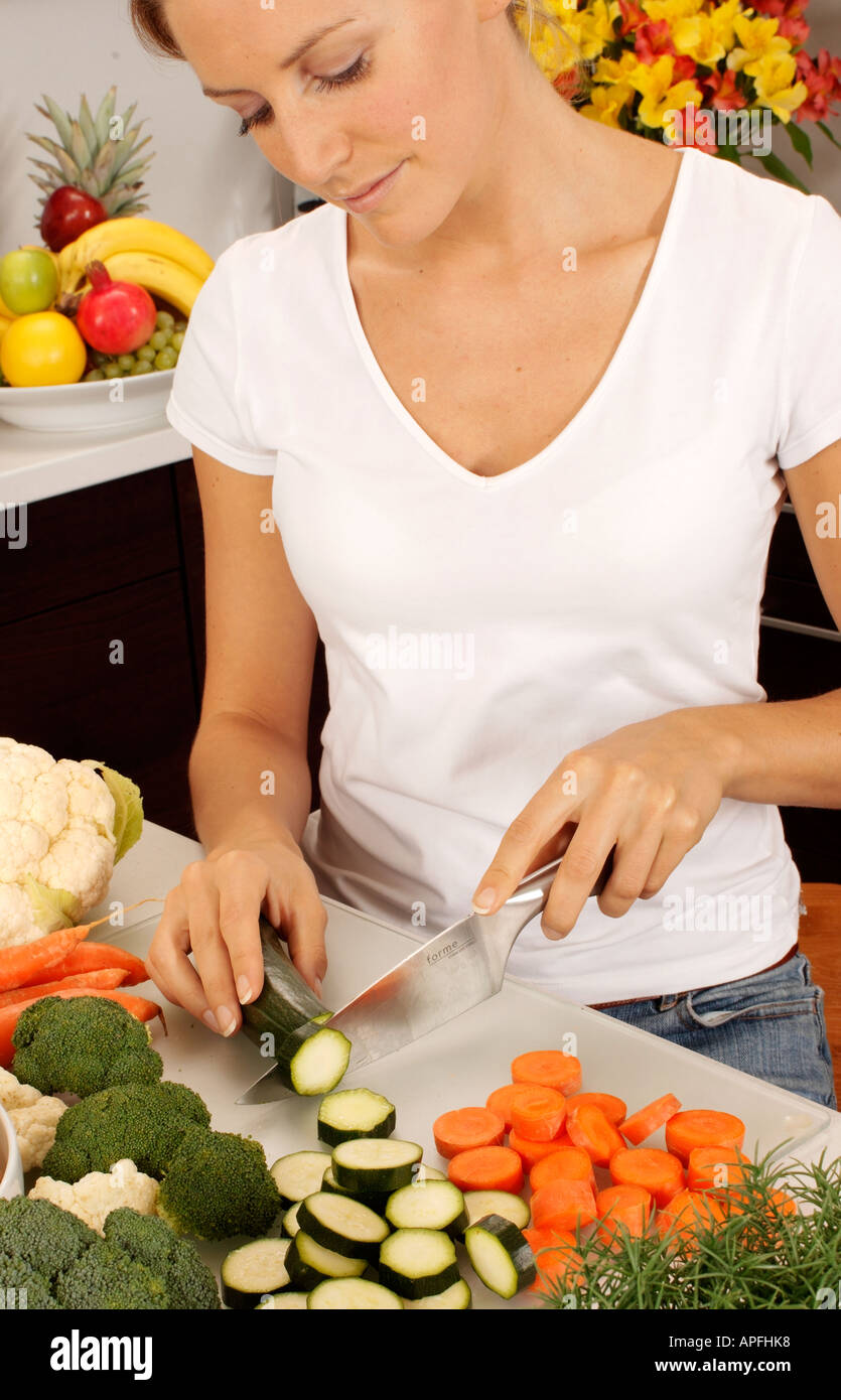 WOMAN IN KITCHEN CHOPPING COURGETTES / ZUCCHINI Stock Photo - Alamy