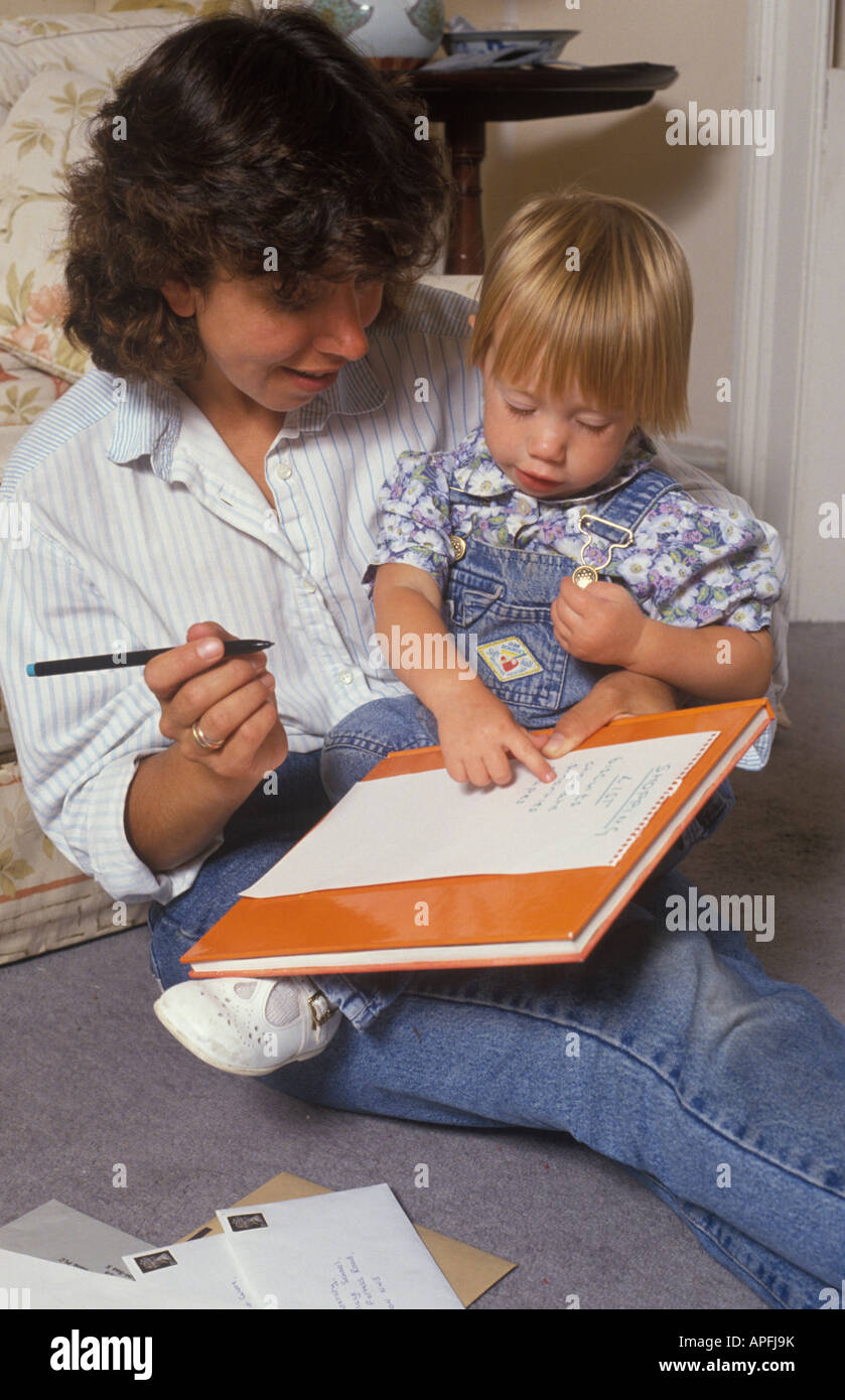 mother writing a list showing her toddler words Stock Photo - Alamy