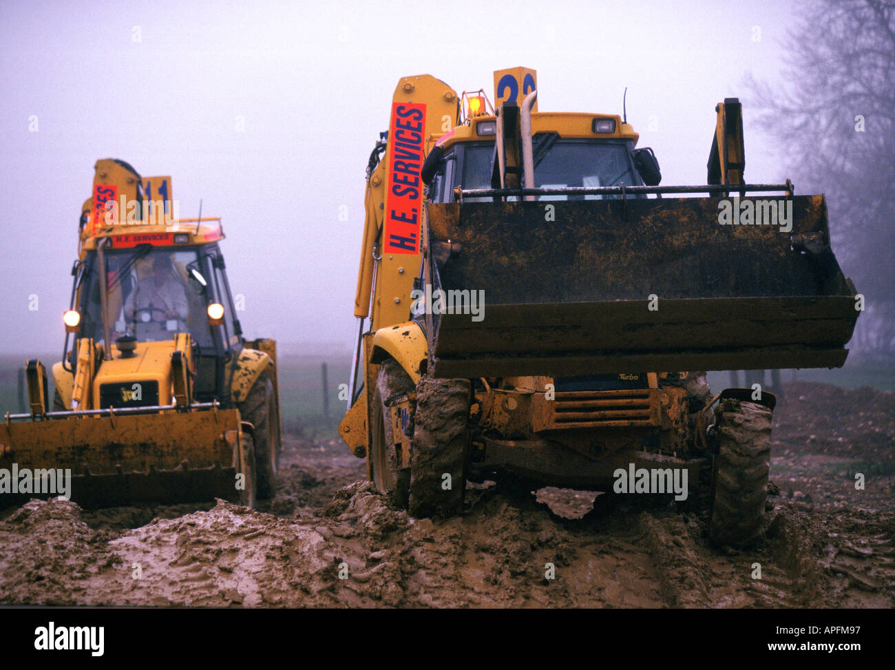 JCB diggers race in mud, UK Stock Photo - Alamy