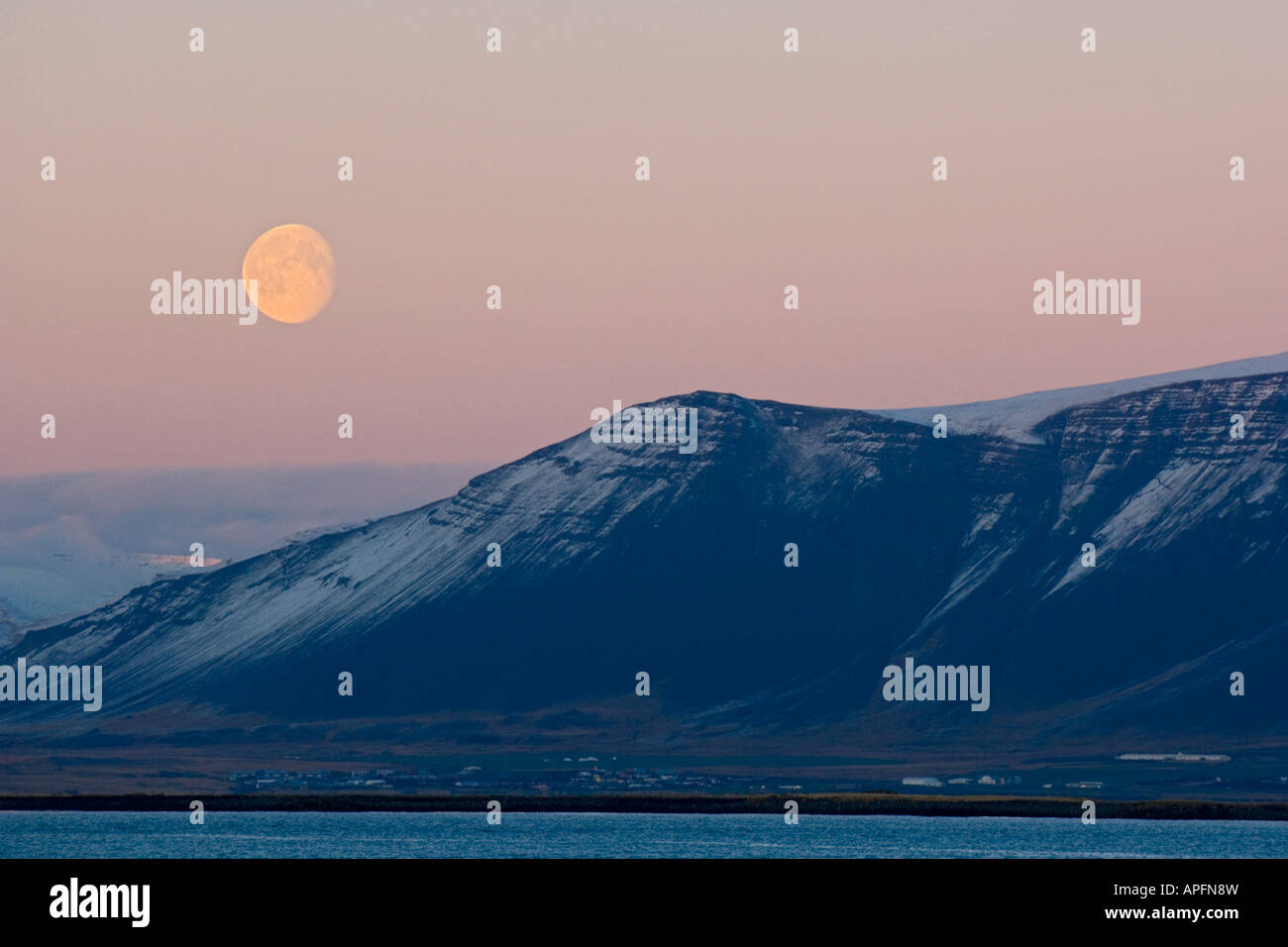 Moon setting over Reykjavik Harbour, Iceland; Mt. Esja in the ...