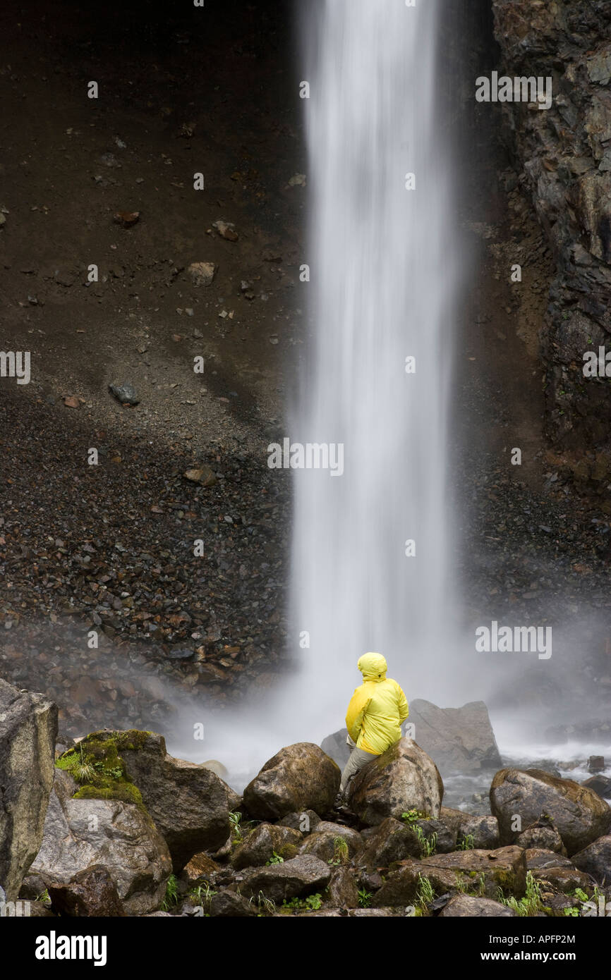 alaska lake clark national park woman in yellow jacket at waterfall ...