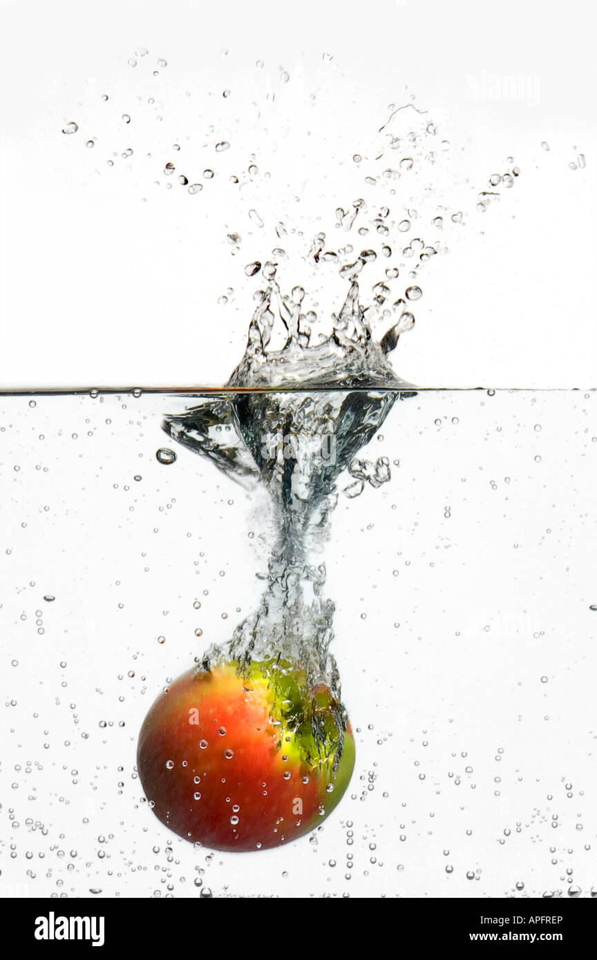 Apple splashing dropping into fizzy carbonated water Stock Photo - Alamy