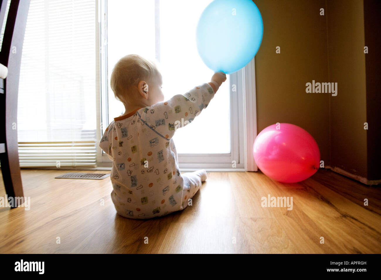 Baby playing with balloons Stock Photo - Alamy