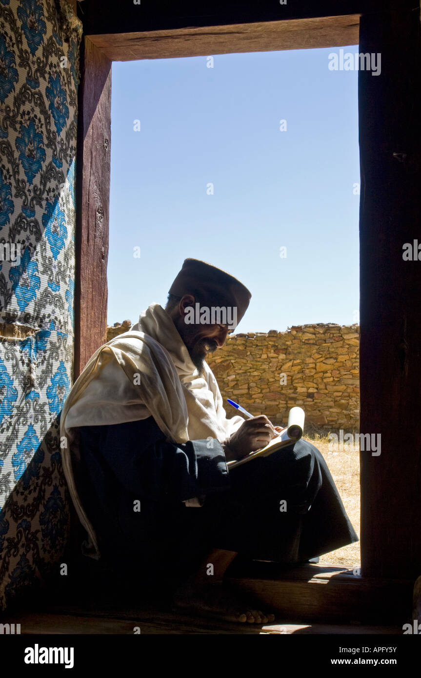One of the monks writing in a book sat in the doorway of the monastery ...