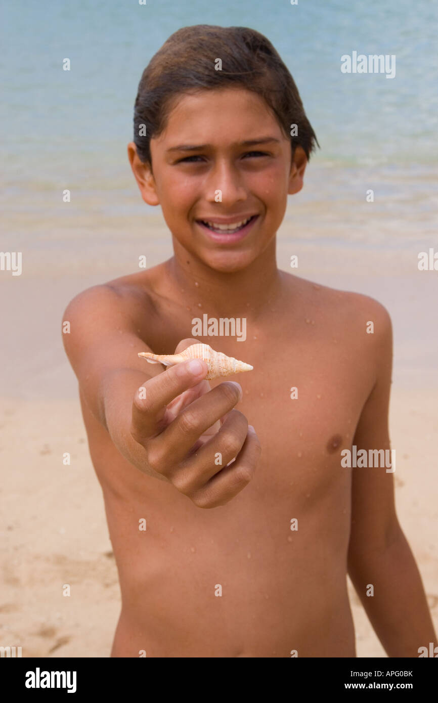 Boy holding a sea shell on a Hawaii beach Stock Photo - Alamy