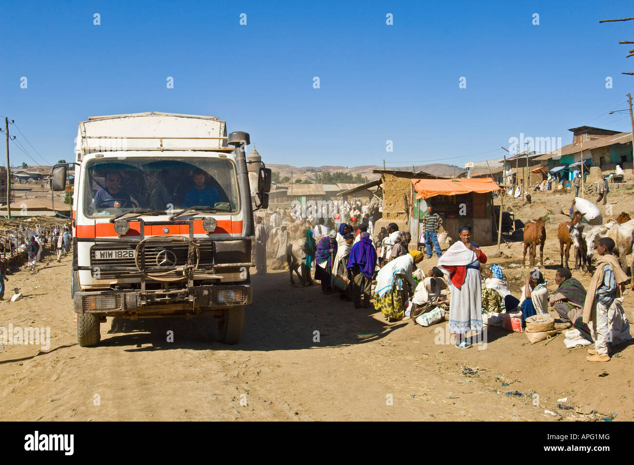 A tourist overland truck travelling through the main market in the town ...