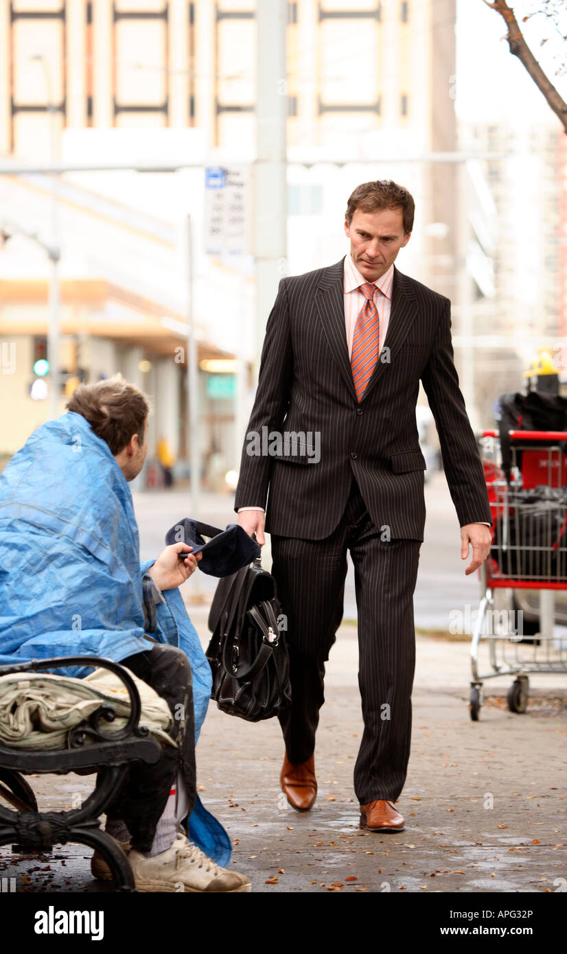 Businessman walking by homeless man Stock Photo, Royalty Free Image ...