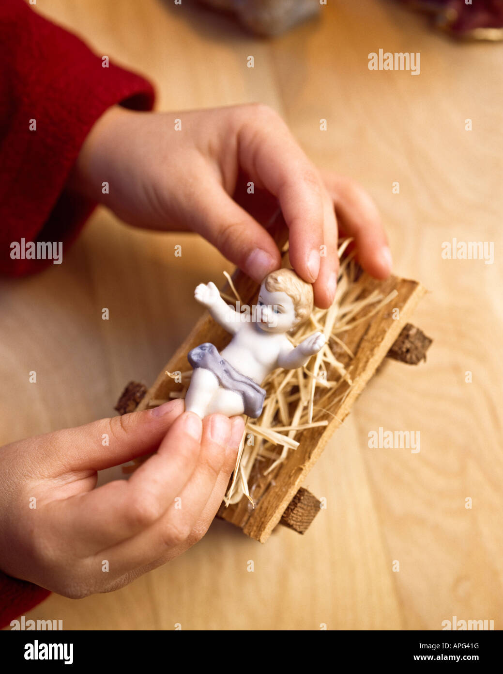 Child playing with figure of baby Jesus Stock Photo - Alamy