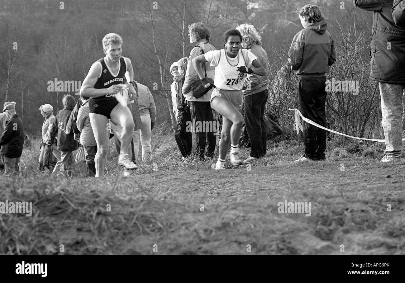 Young cross country runner with spectators climbing hill Stock Photo ...