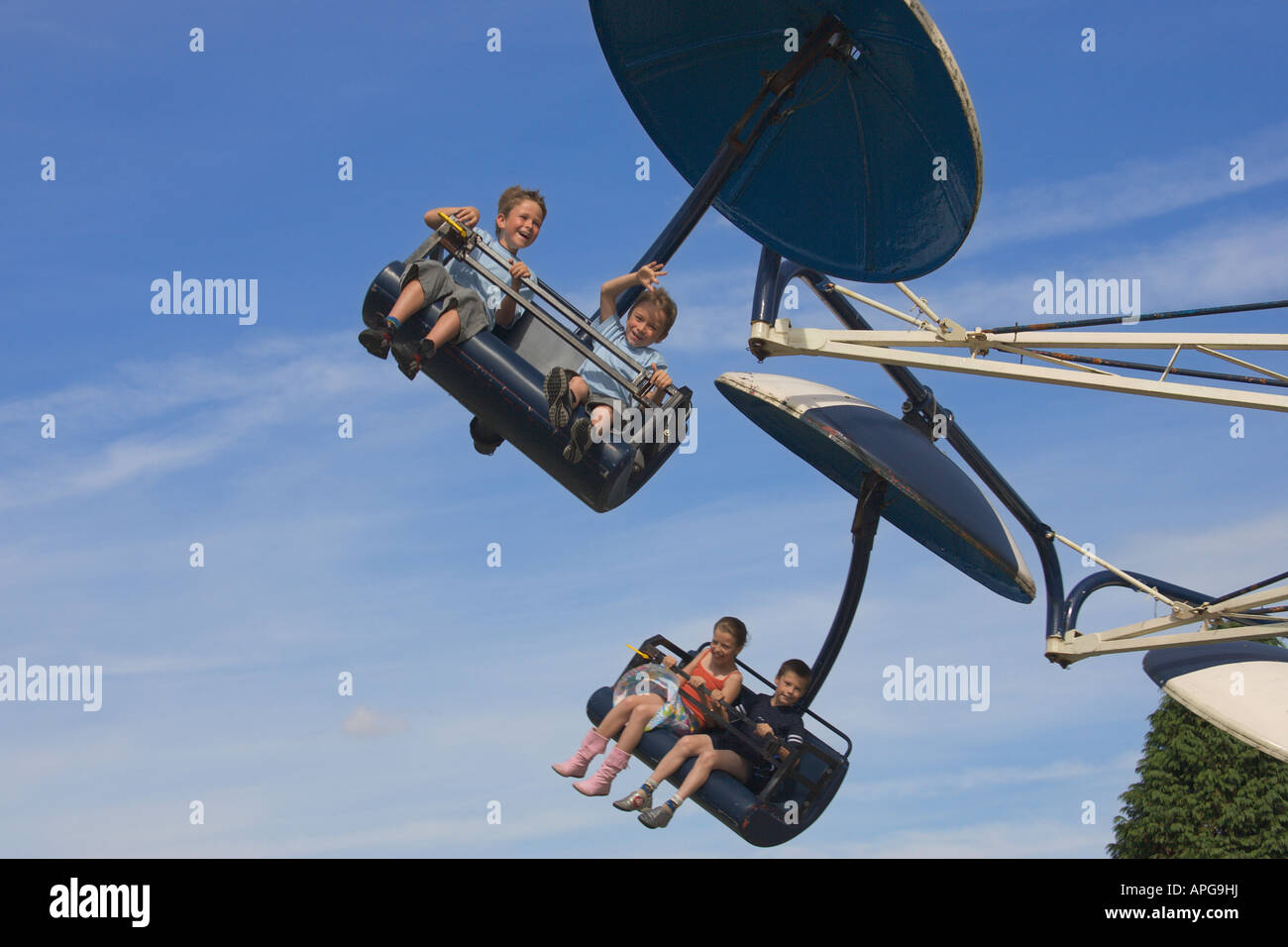Four children enjoying a fairground ride Stock Photo - Alamy