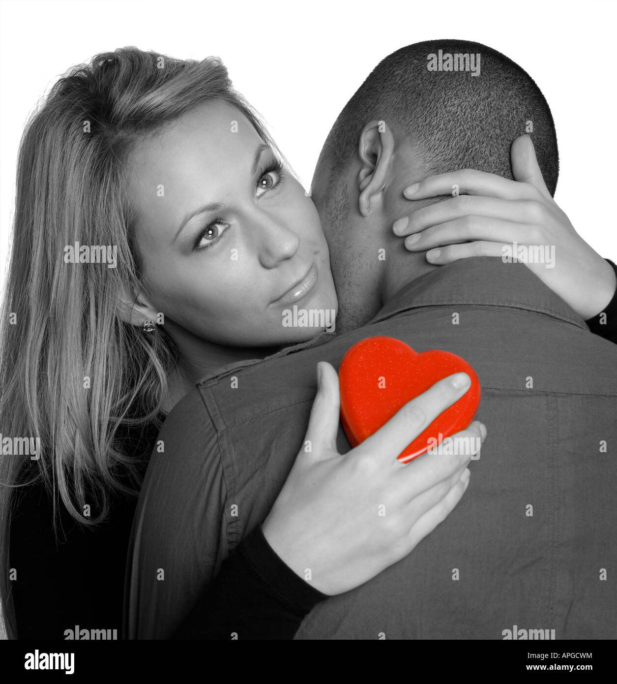 couple cuddling with a valentines day gift heart shaped box Stock Photo ...