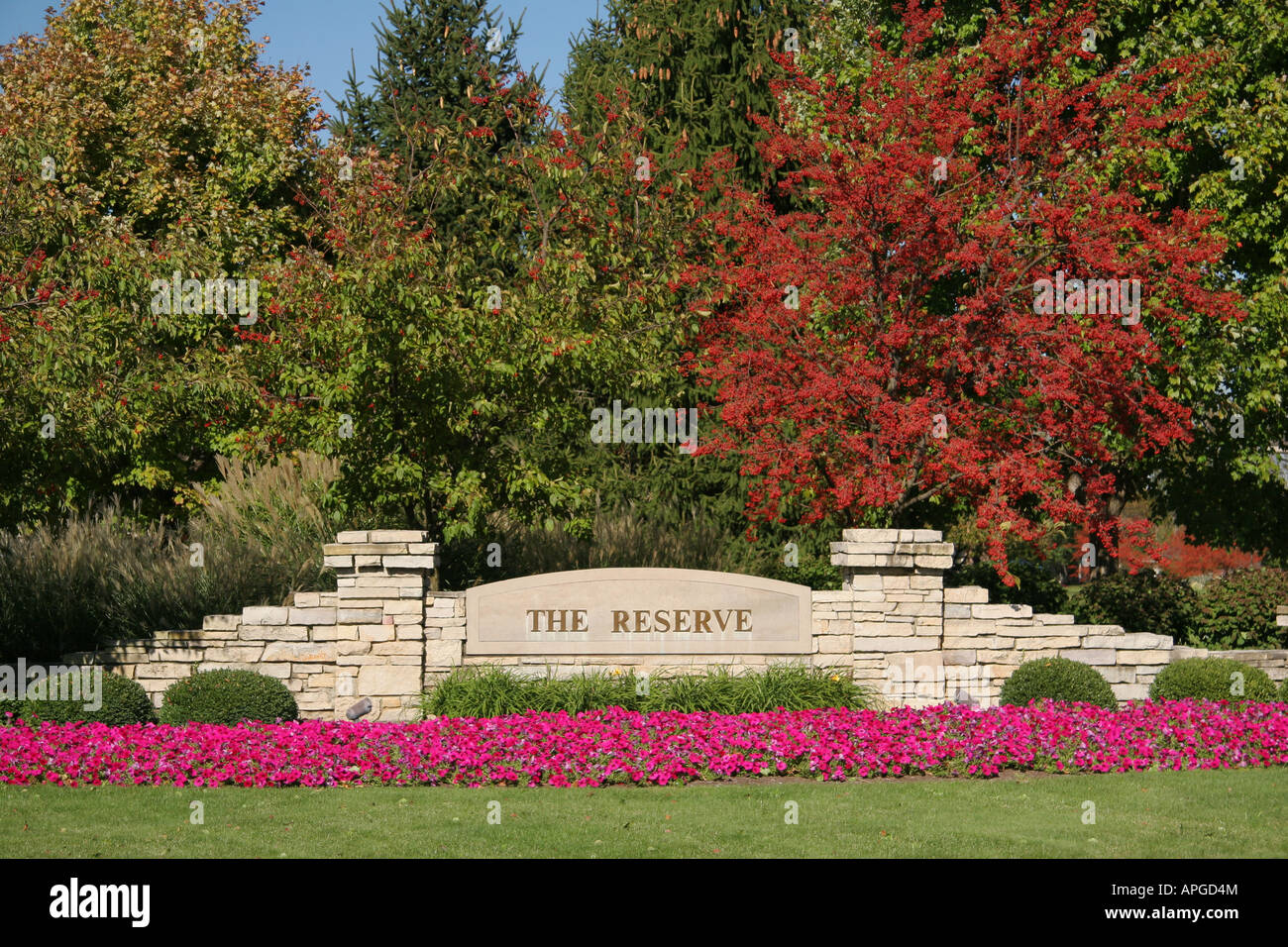 Stone Wall Sign Autumn colors Professional landscaping Stock Photo - Alamy