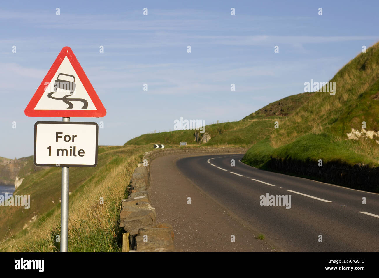 triangular red lined slippery road for one mile warning road sign on ...