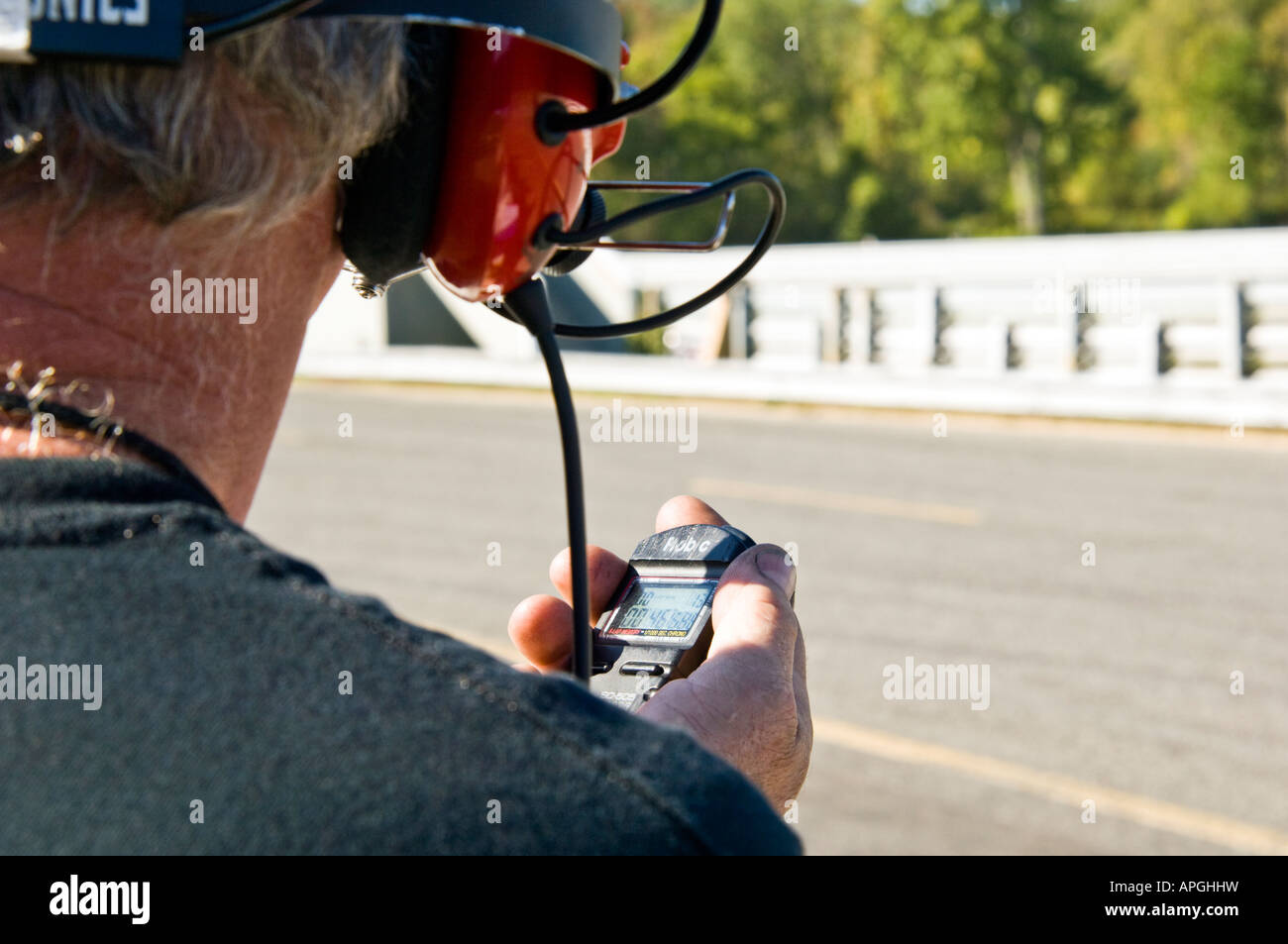Motor racing team member checks lap times and communicates with driver ...