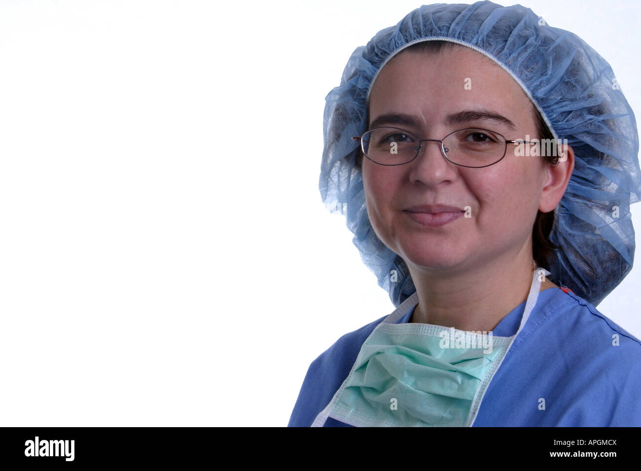 A closeup of a nurse or surgeon wearing scrubs, glasses, hair bonnet ...
