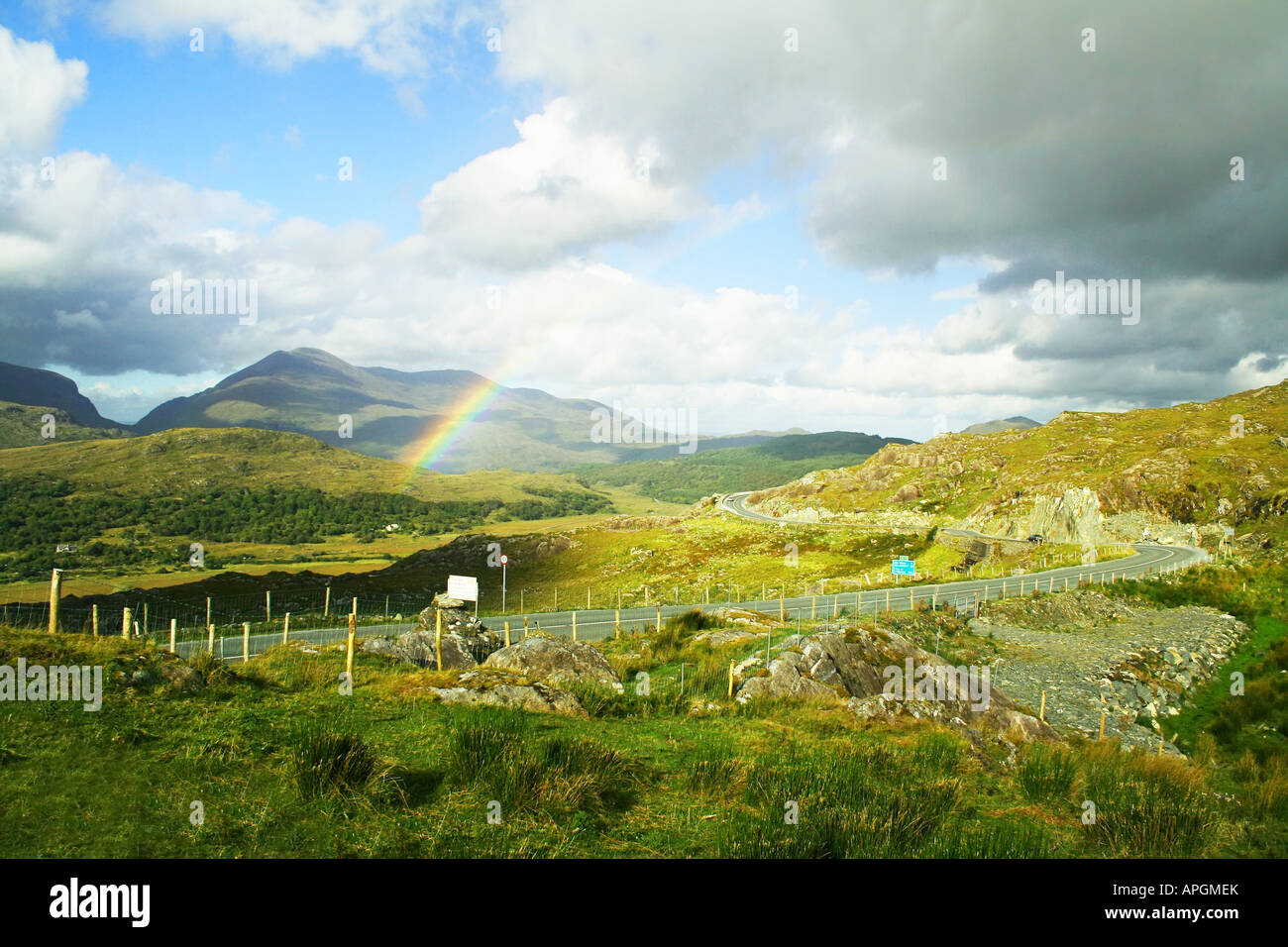 winding highway at the Gap of Dunloe with rainbow in Irish Highlands ...