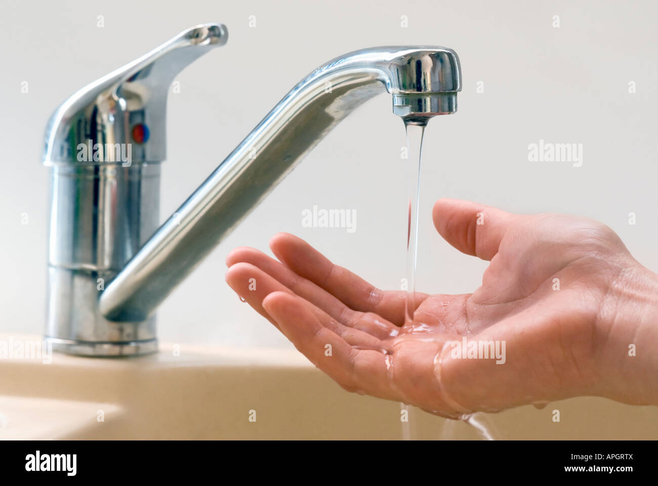 A woman rinsing her hands under the tap Stock Photo - Alamy