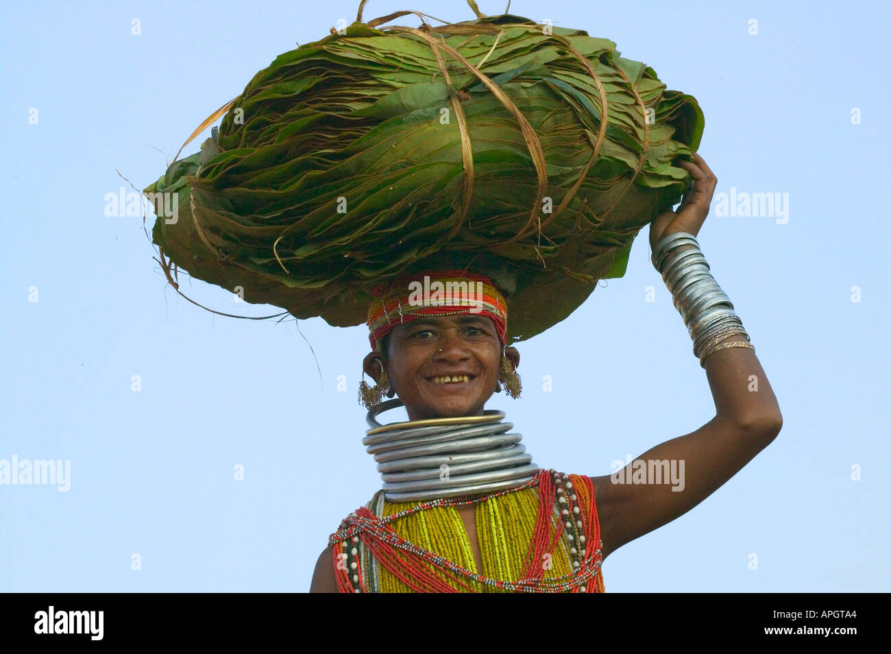 Portrait of a Bondo woman in traditional bead costume carrying loads on ...