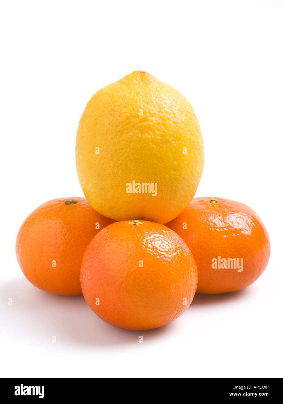 Three tangerines and a lemon on a white background Stock Photo - Alamy