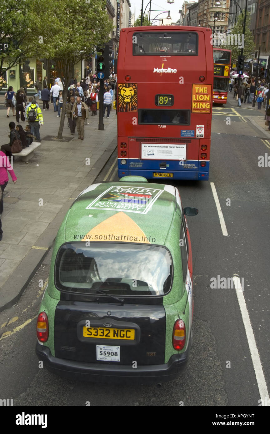 Green London taxi and red double decker bus on Oxford Street, London ...