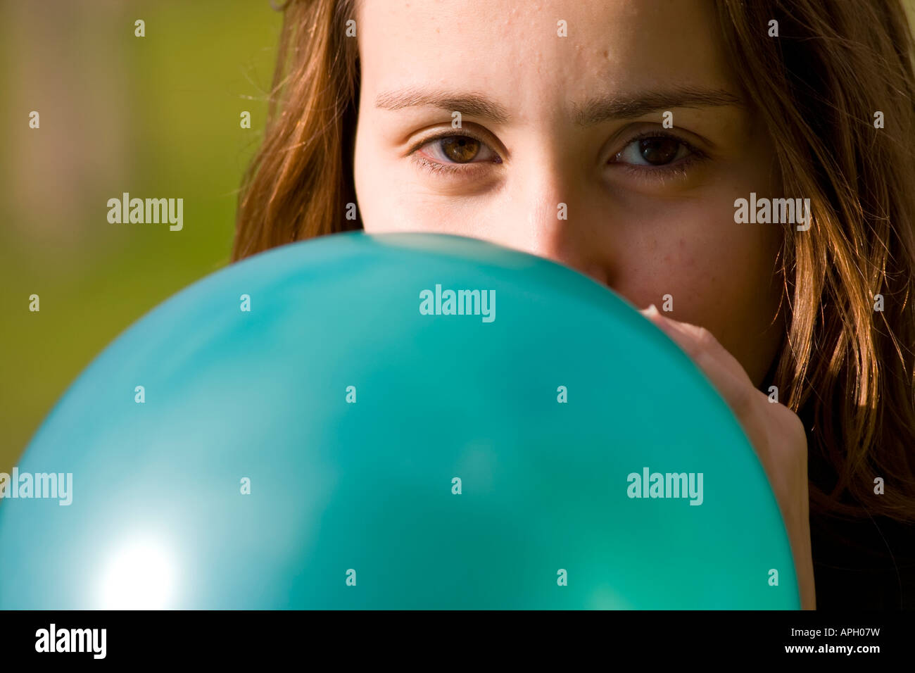 Closeup on woman inflating blue balloon Stock Photo - Alamy