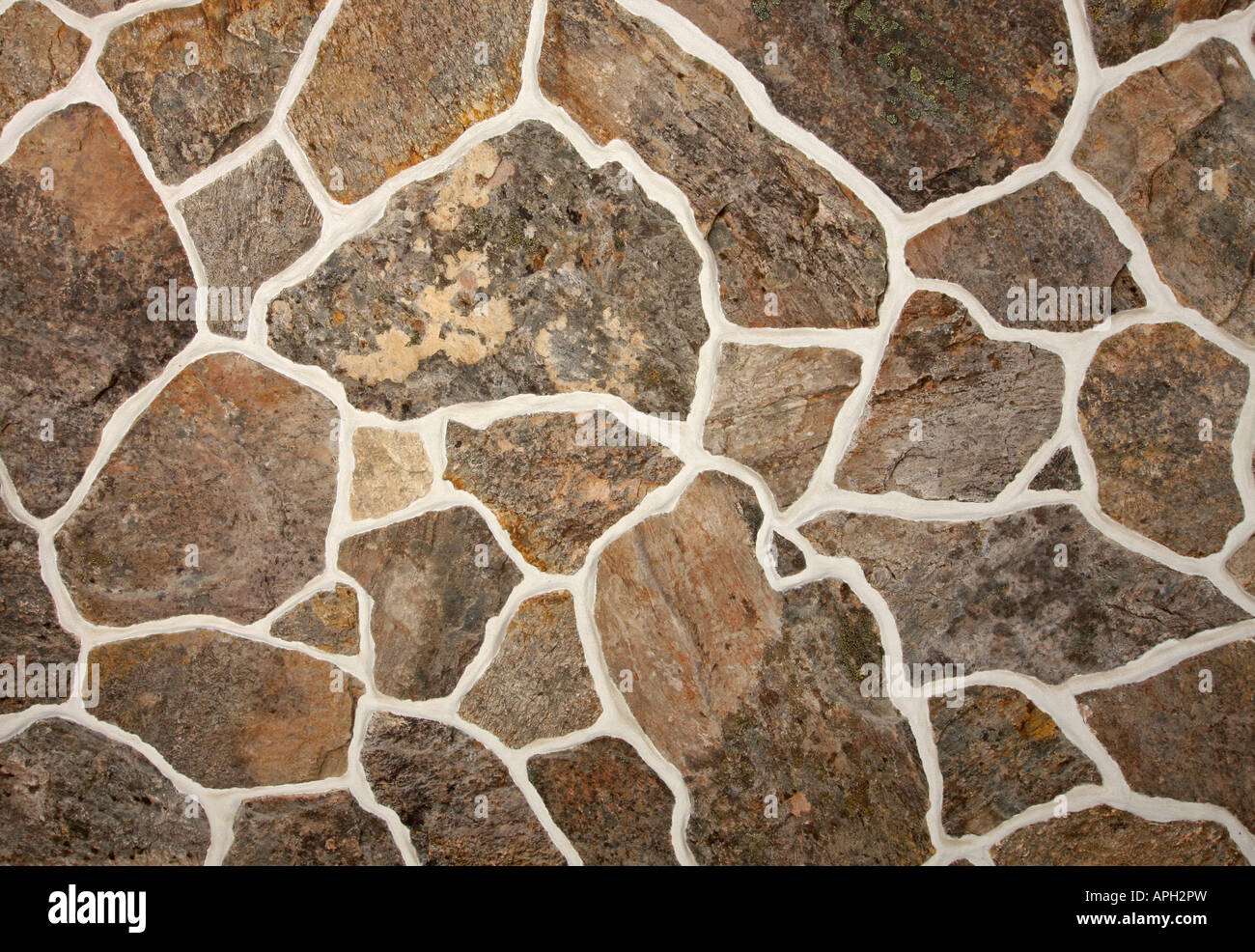 Old fashioned stone wall pattern with different sizes of stone lit with ...