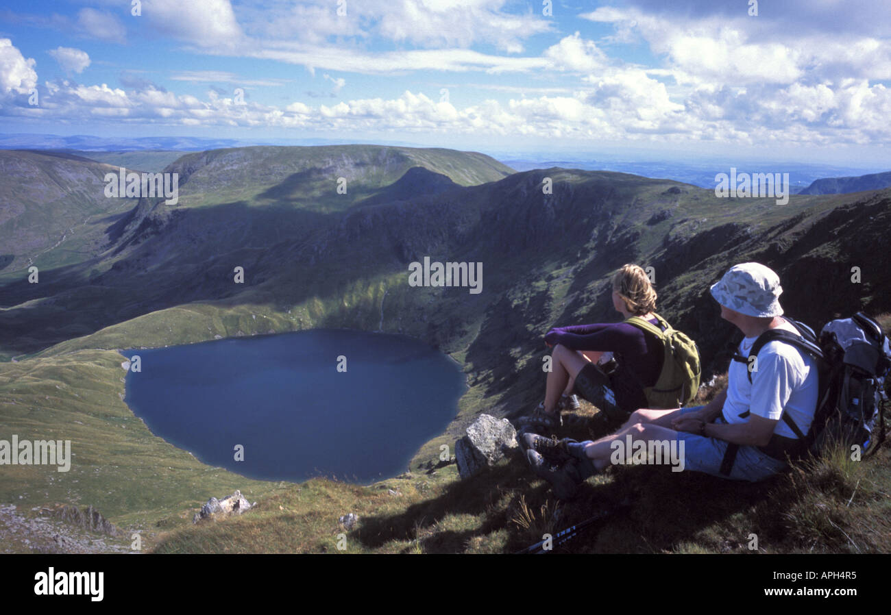 Walkers resting overlooking Blea Water glacial tarn from High Street in ...