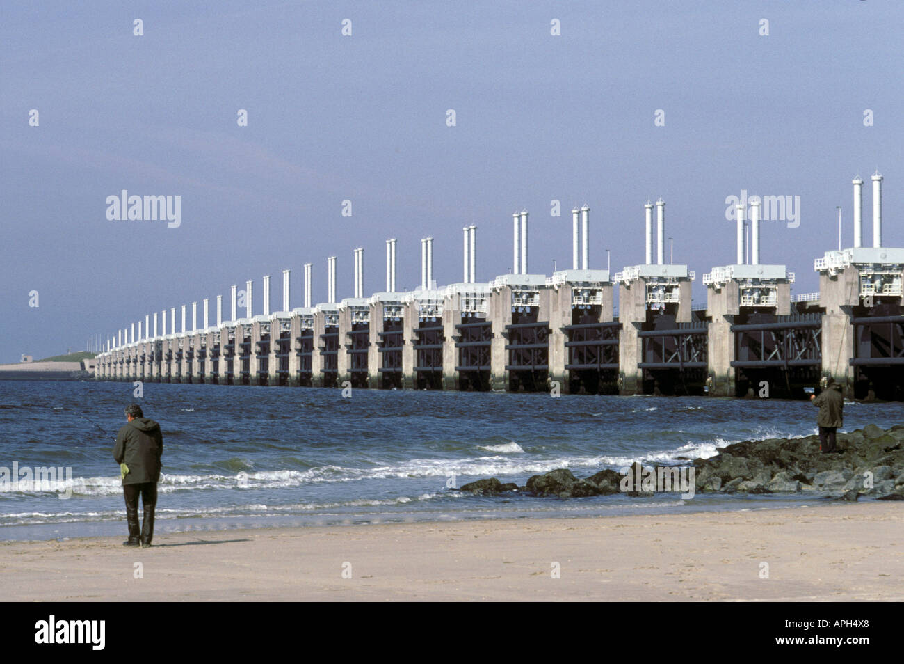 Men fishing next to the Oosterschelde flood prevention barrier Holland ...
