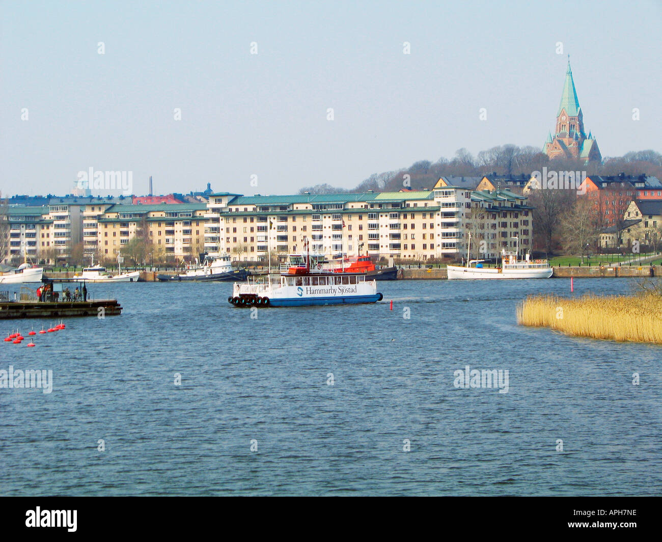 A ferry crosses the Hammarby Sjö lake in the modern residential area ...