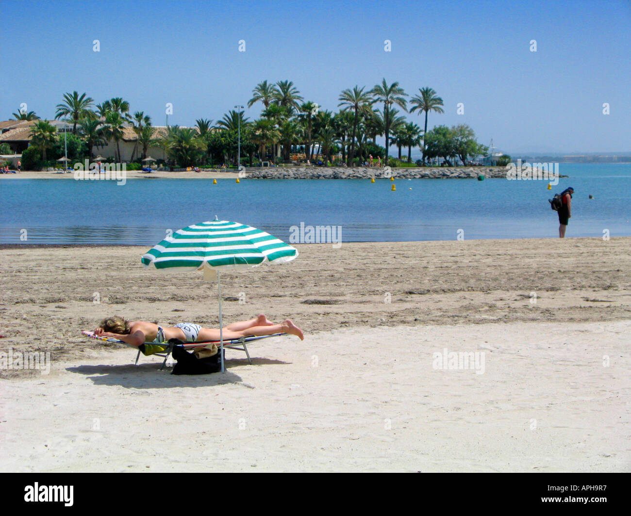 Tourists enjoy the Spanish sun at Platja d’Alcudia beach in Alcudia ...