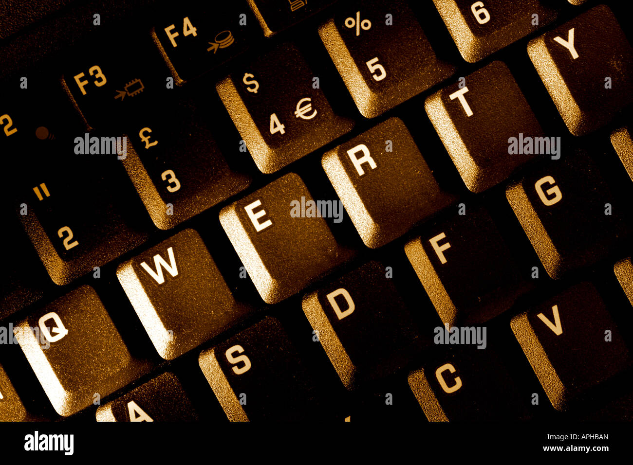 Close-up of QWERTY keys on computer keyboard with warm side-lighting ...