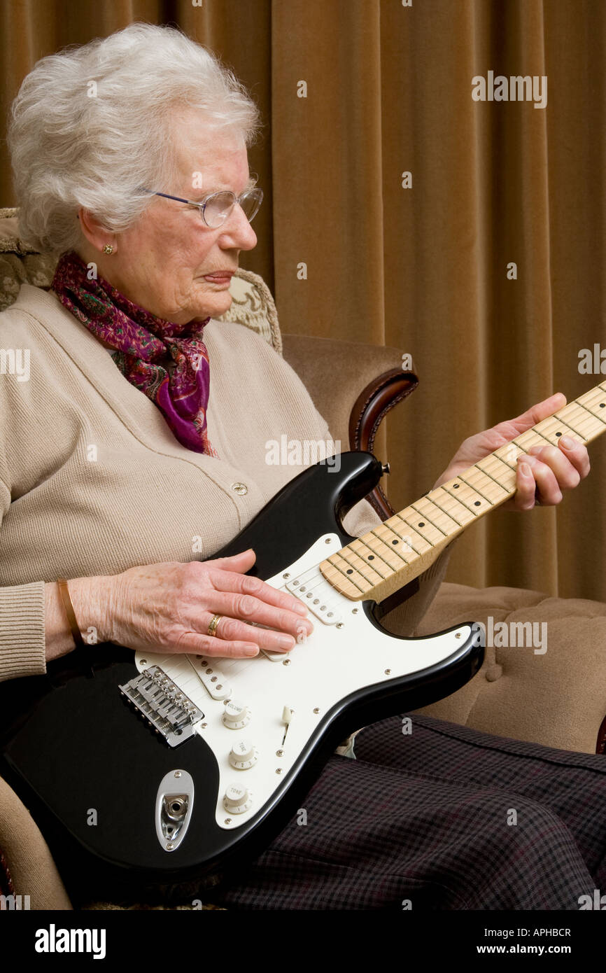 Elderly lady playing a guitar Stock Photo - Alamy