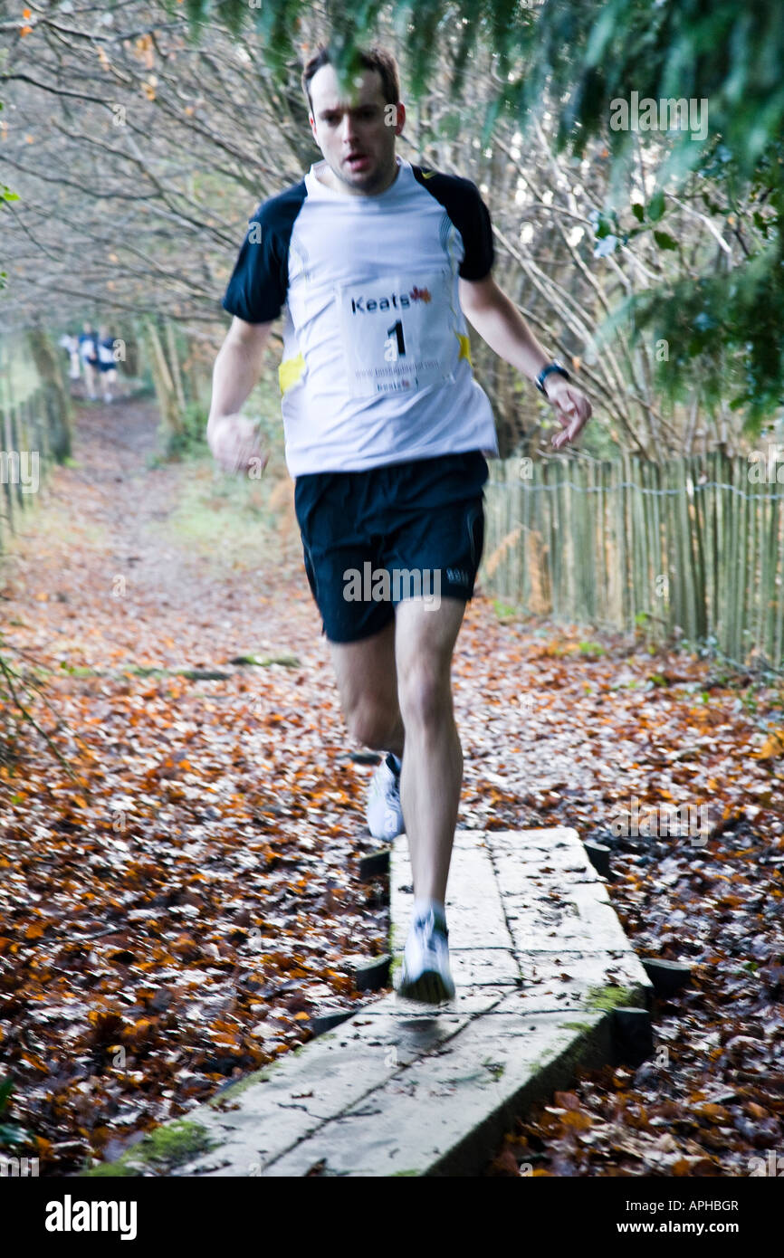 The leading cross country runner negotiates a slippery board walk in a ...