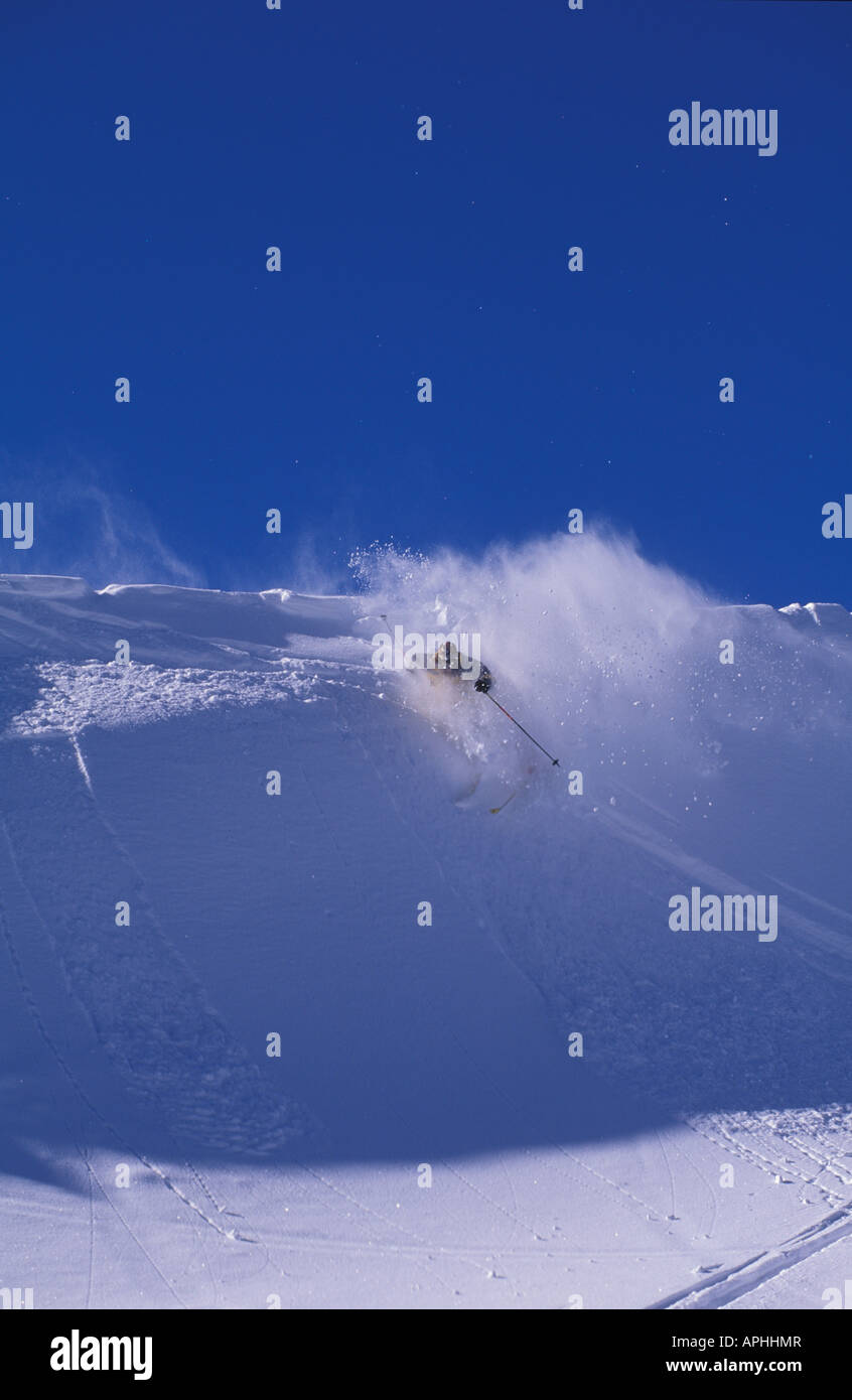 A male skier bursts through a cornice in deep powder snow in Crested ...